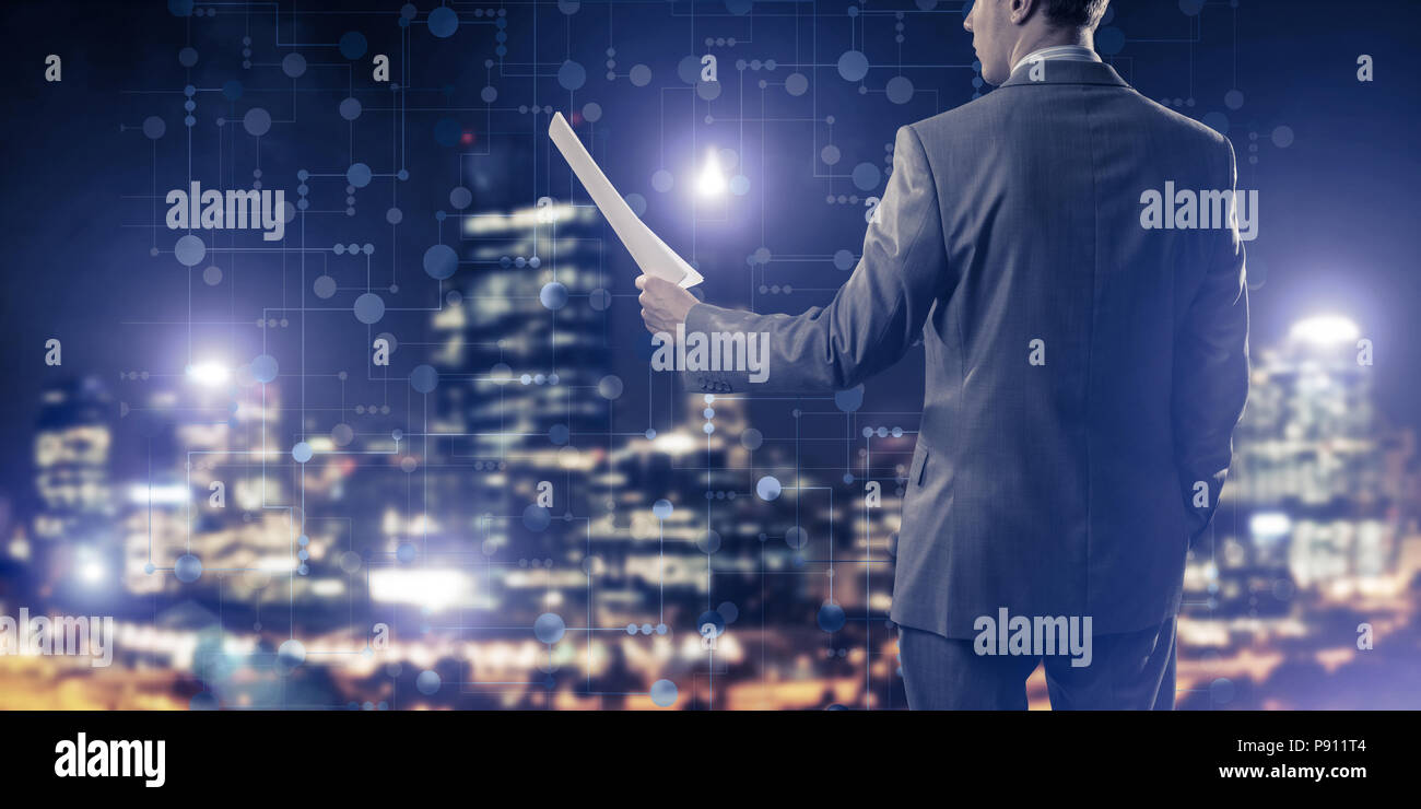 Rear view of businessman against night cityscape background and Stock ...