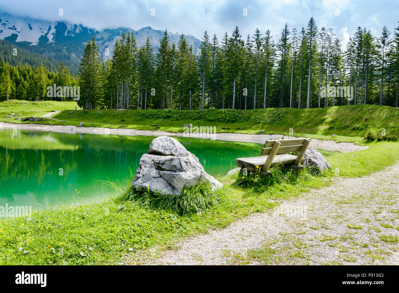 Bench near Ehrwalder Almsee lake in the Alps mountains - Tyrol, Austria ...