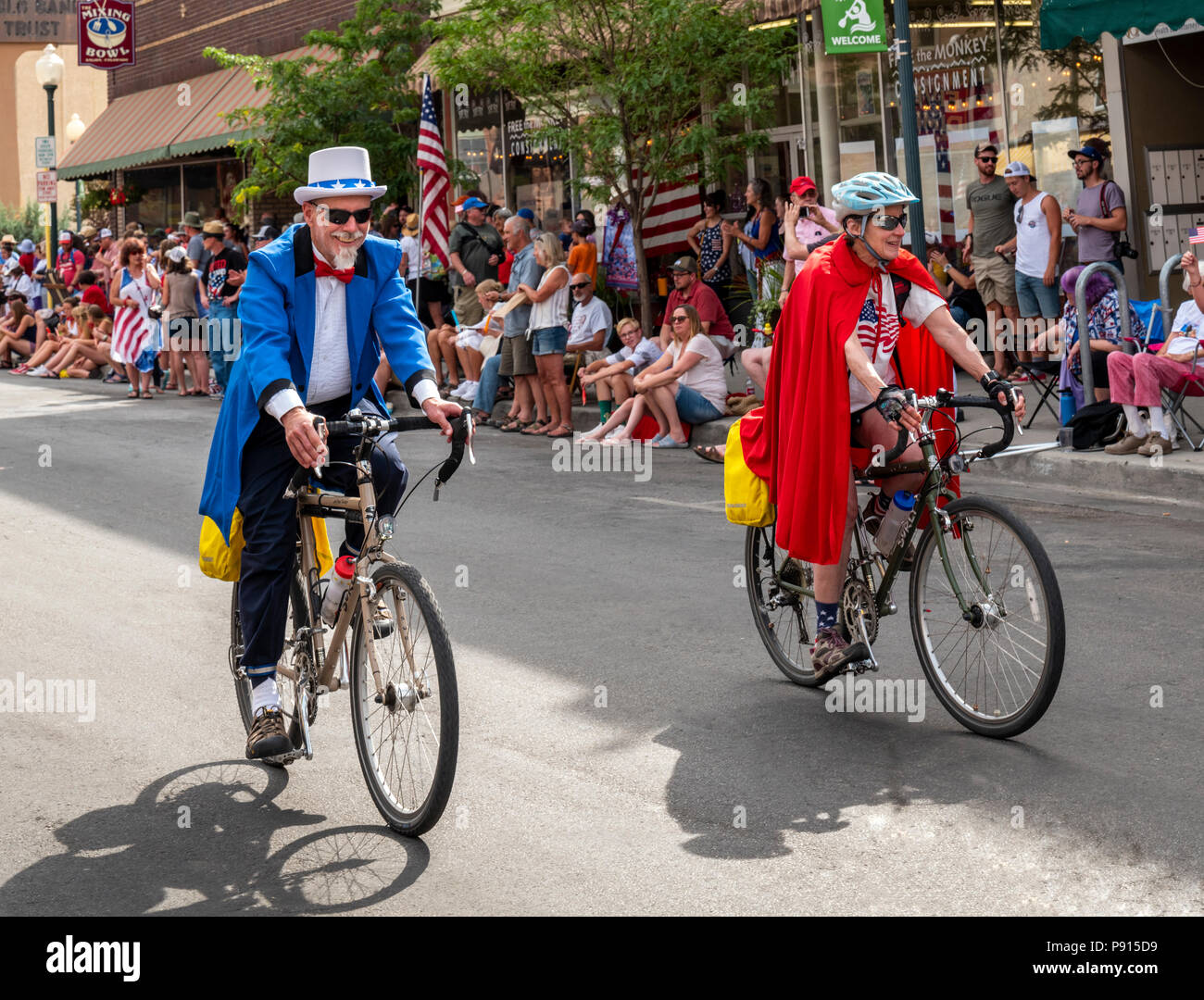 Colorful couple riding bicycles in annual Fourth of July Parade in the small mountain town of ...