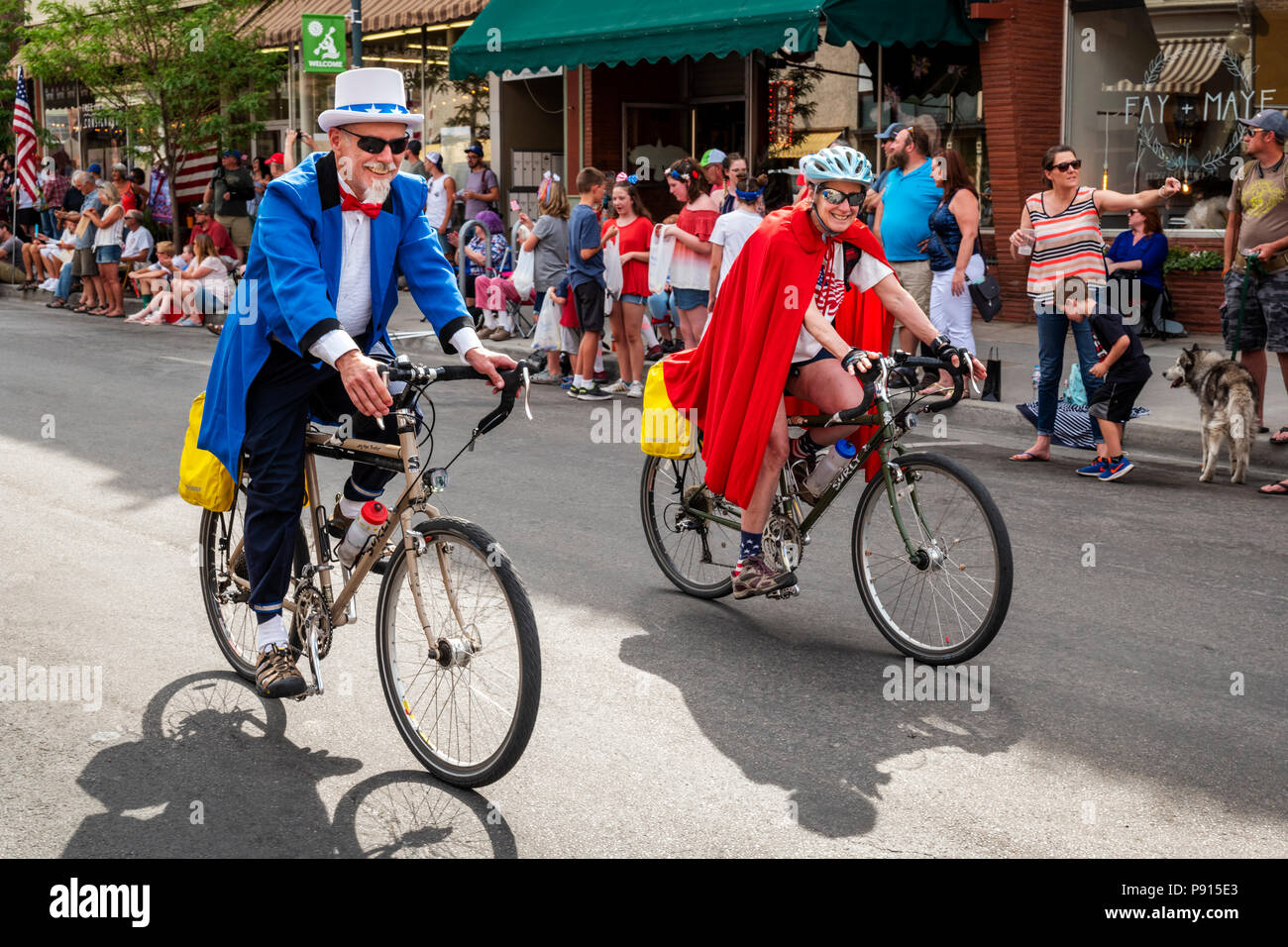 Colorful couple riding bicycles in annual Fourth of July Parade in the small mountain town of ...
