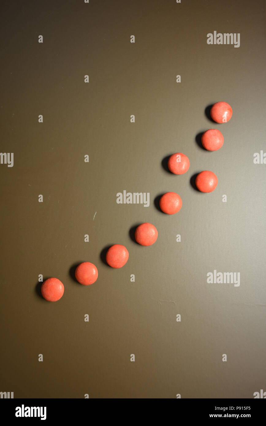 Matte beautiful sweets, shivering candy red on a brown matte background ...