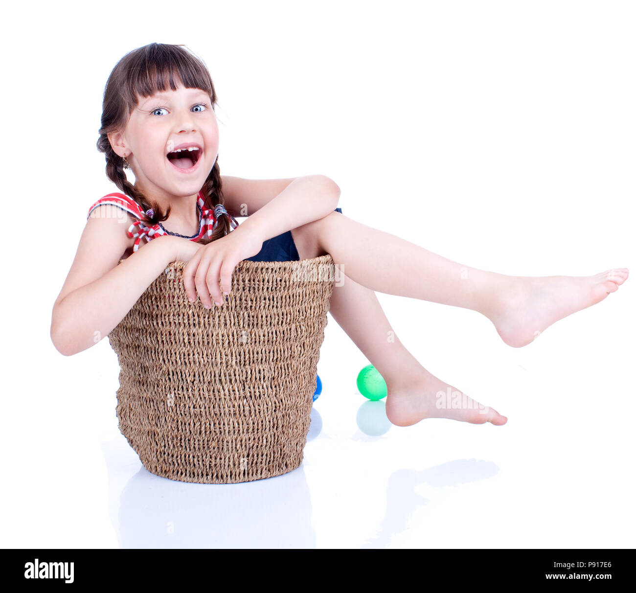 Cute girl sitting inside the basket, studio shot Stock Photo - Alamy
