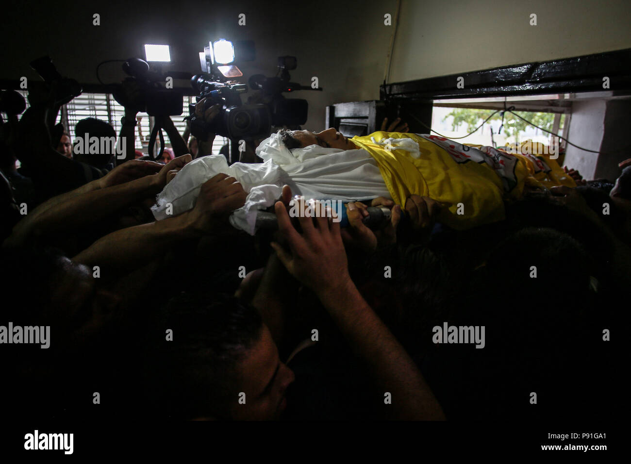 Gaza. 14th July, 2018. Mourners and relatives carry the body of 15-year ...