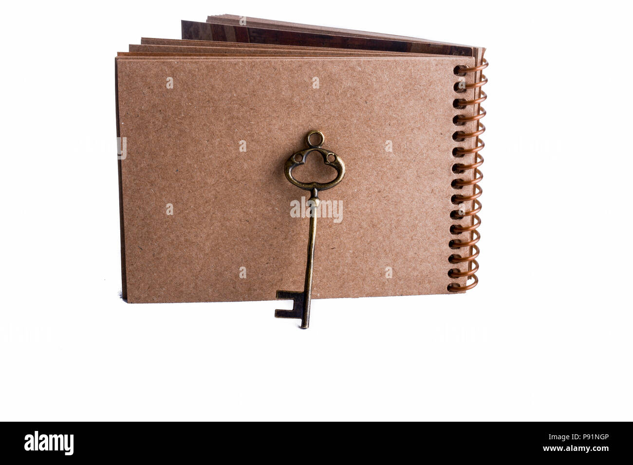 key by the side of a spiral notebook on a white background Stock Photo ...