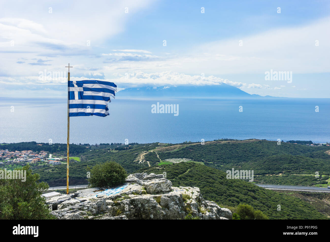 The Greek National Flag waving over seascape and Samothraki island as ...