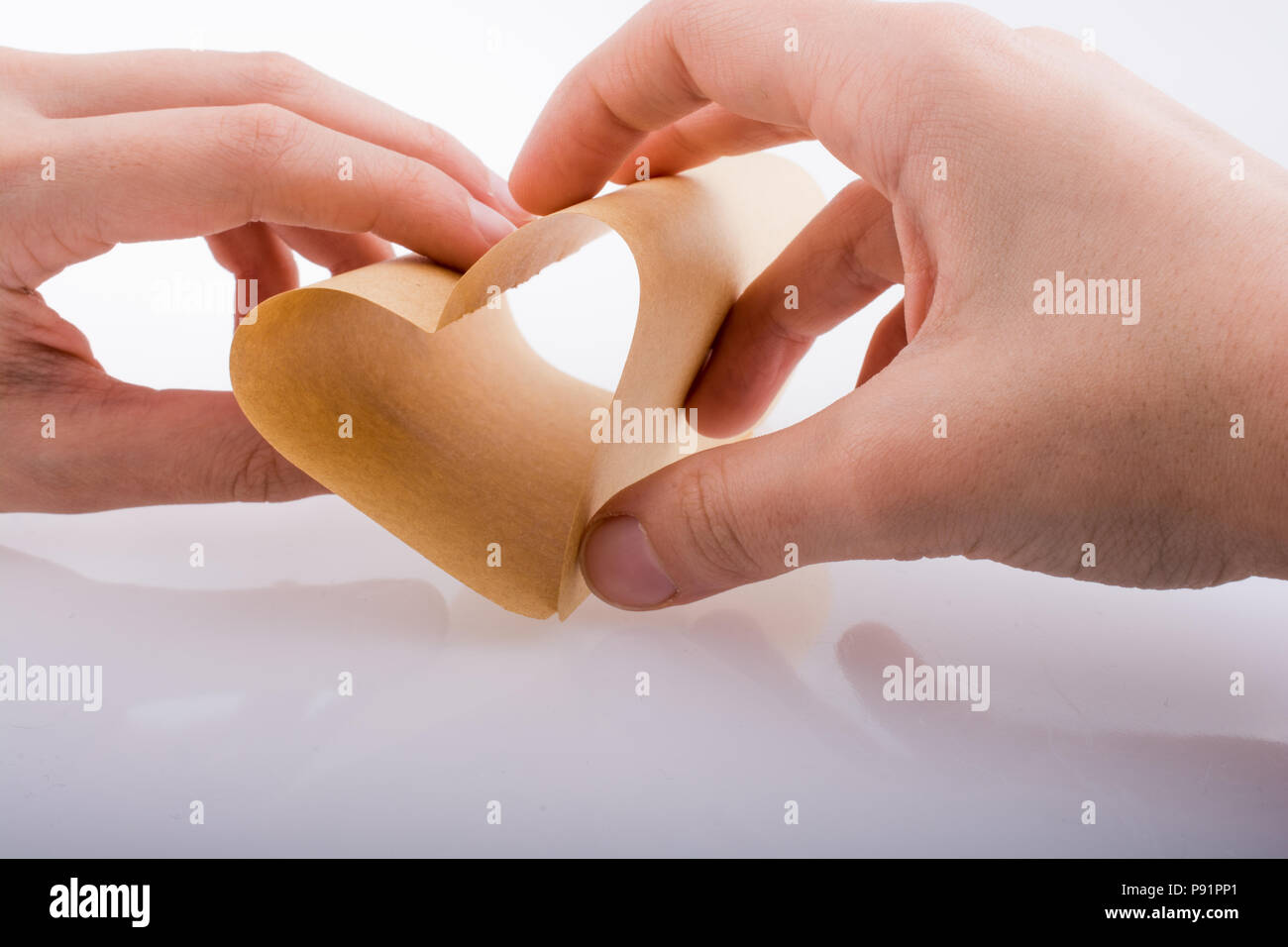 Paper forming a heart shape in hand on a white background Stock Photo ...
