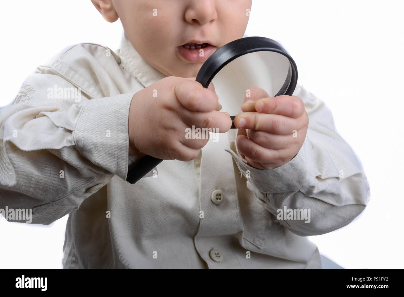 Baby holding a magnifying glass in hand on a white background Stock ...