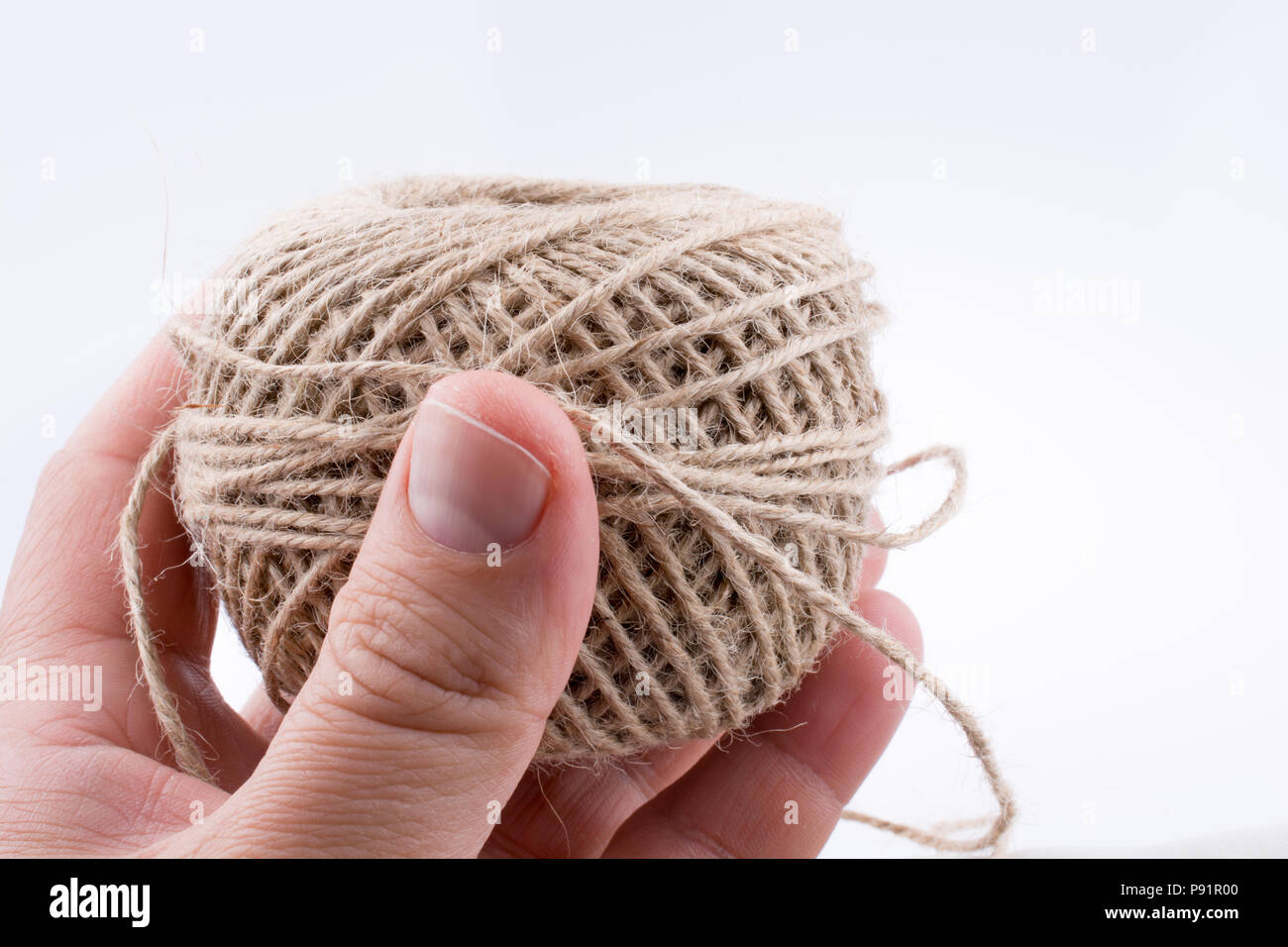 Spool of linen thread in hand on white background Stock Photo - Alamy