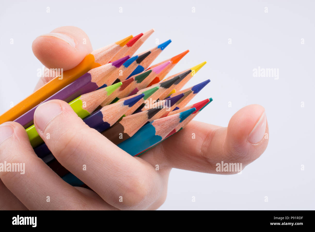 Hand holdin color pencils on a white background Stock Photo - Alamy