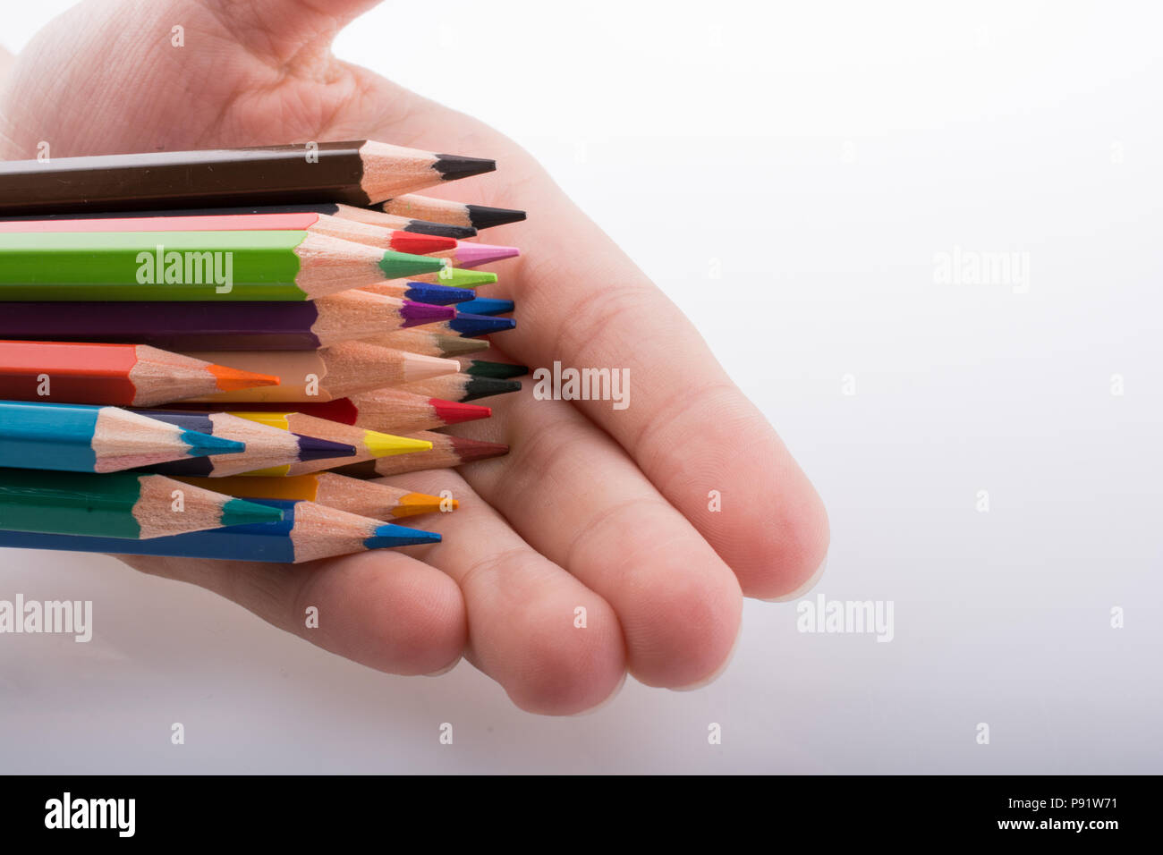 Hand holding color pencils on a white background Stock Photo - Alamy