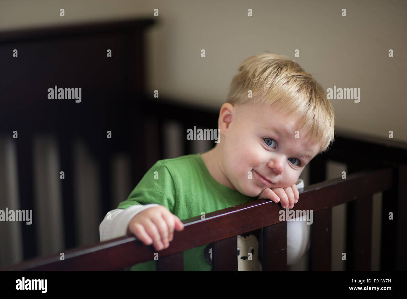 Toddler is in his crib smiling while wanting to get out Stock Photo - Alamy