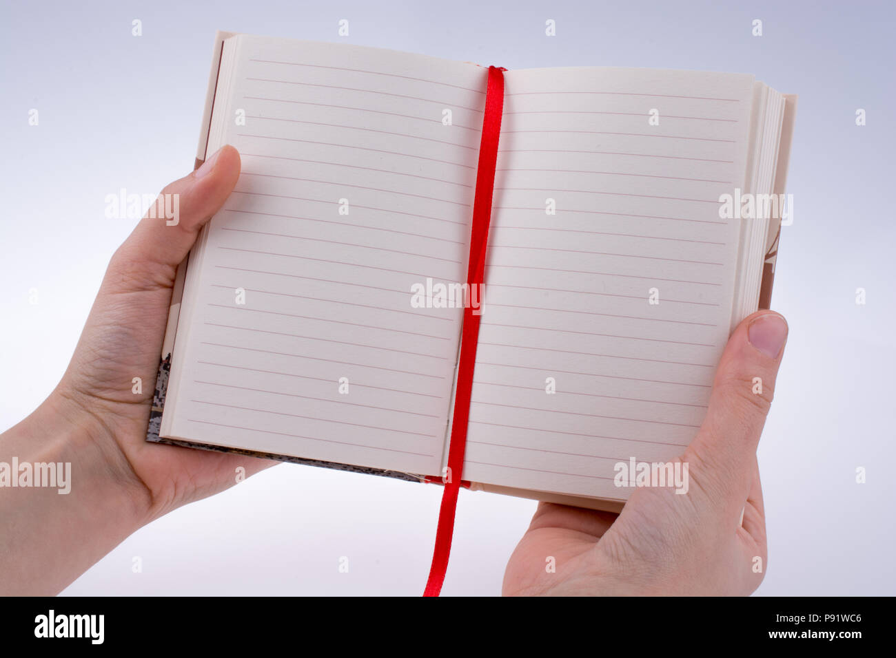 Hand holding a notebook on a white background Stock Photo - Alamy