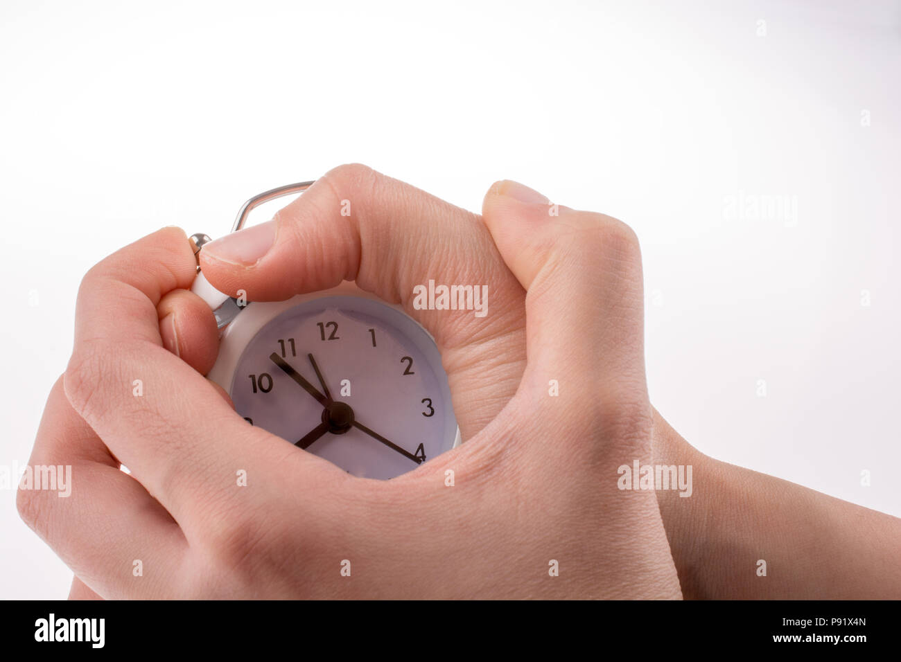 Alarm clock in hand on a white background Stock Photo - Alamy