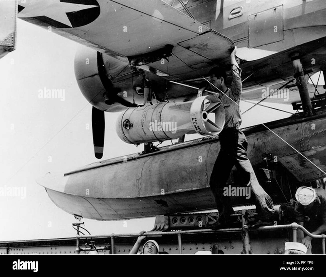 A depth bomb is removed from a SOC Seagull aboard USS Philadelphia (CL ...