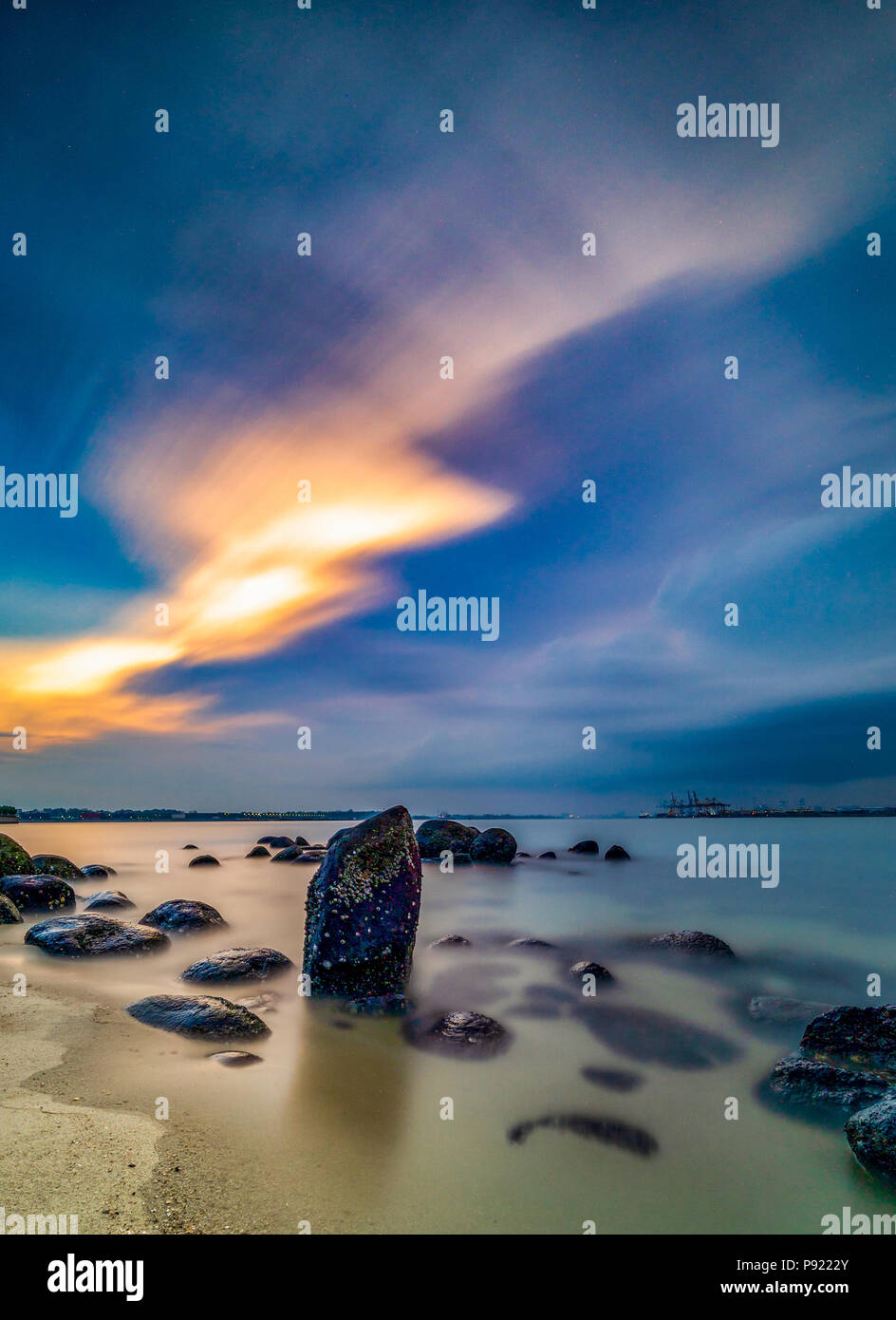 Rocks At Beach During Dusk Stock Photo - Alamy