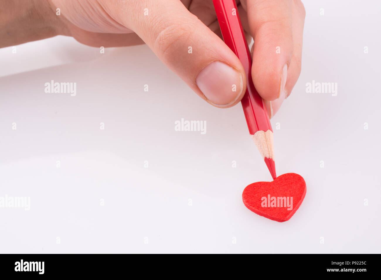Pencil pointing a red heart Stock Photo - Alamy