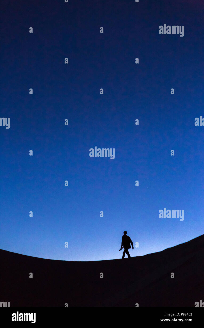 Silhouette of adventuring man in sand dunes Stock Photo - Alamy