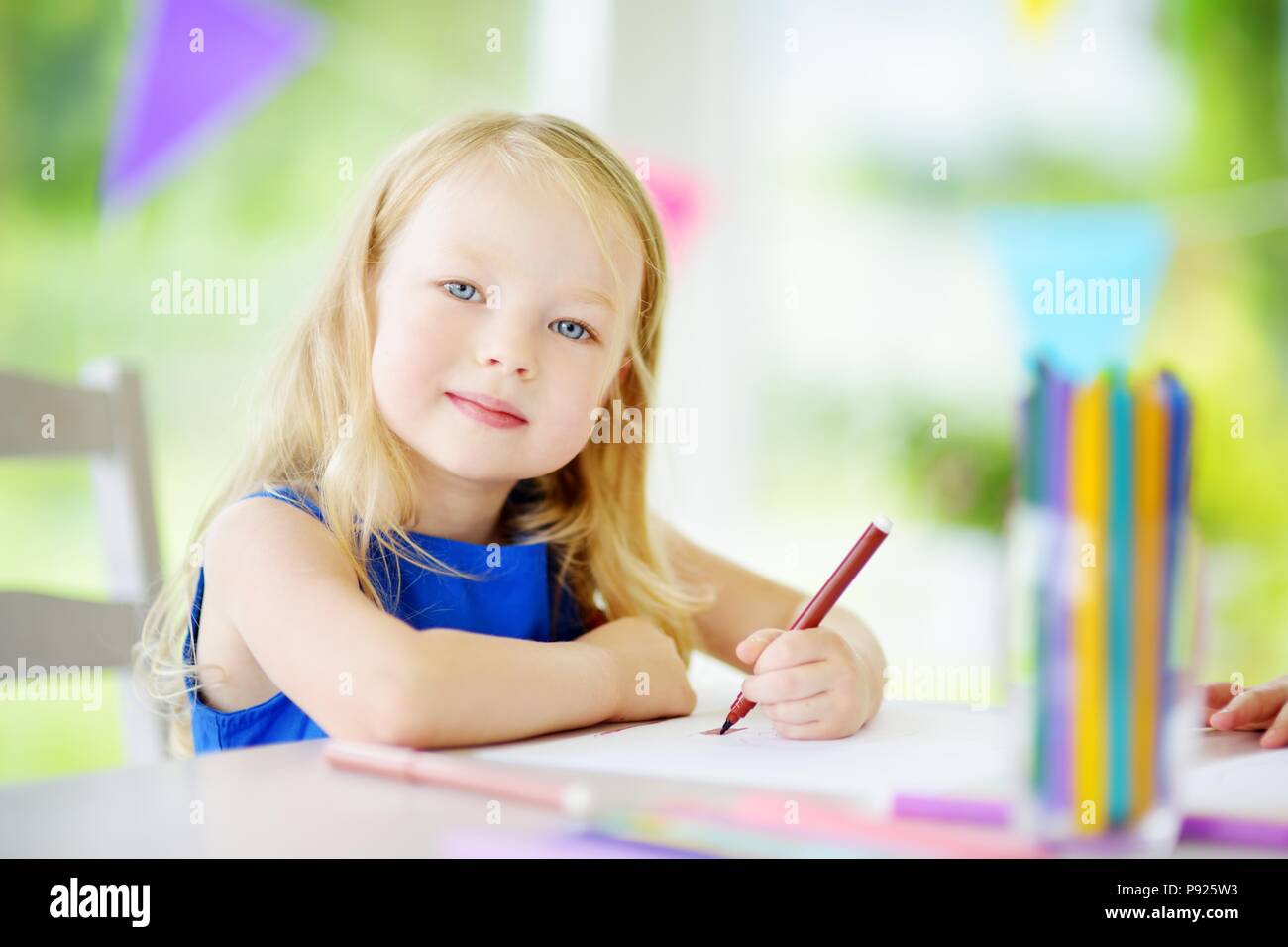 Cute little girl drawing with colorful pencils at a daycare. Creative ...