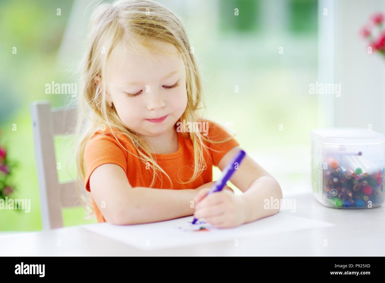 Cute little girl drawing with colorful pencils at a daycare. Creative ...