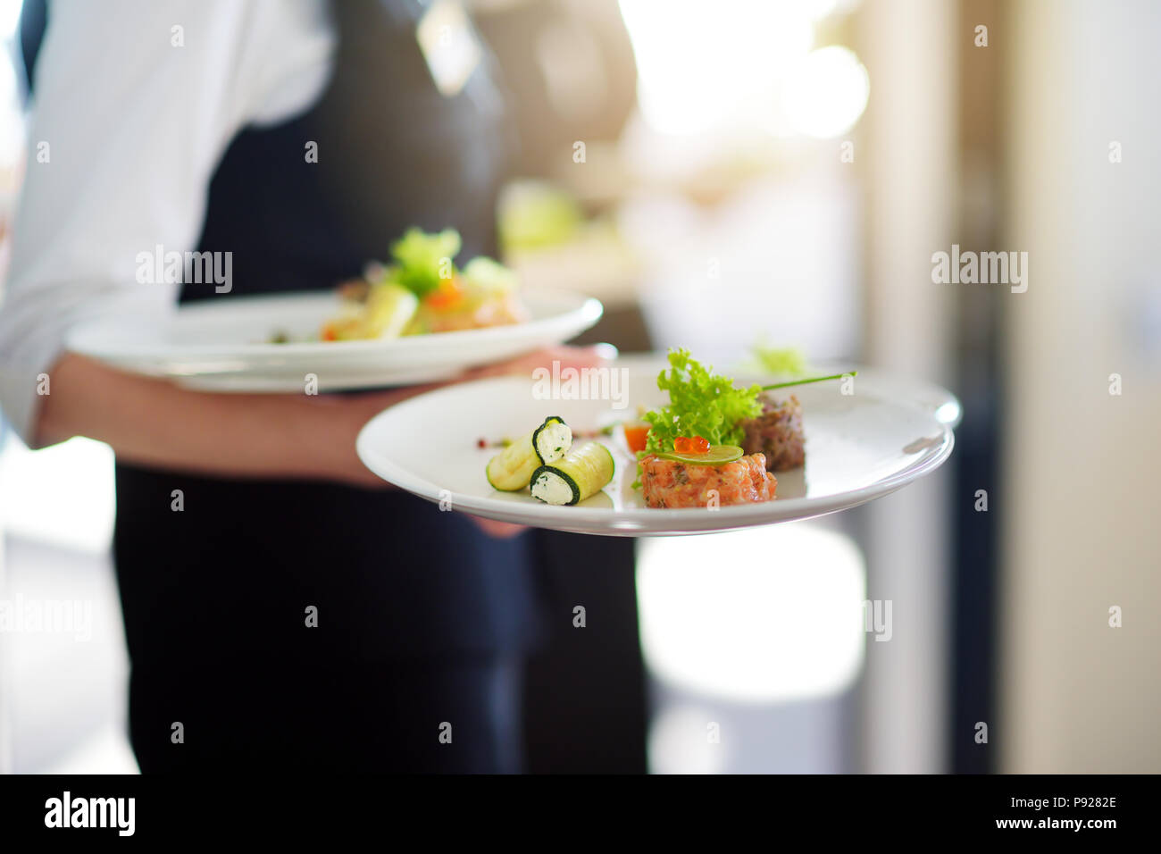 Restaurant waiter carrying plates food hi-res stock photography and ...