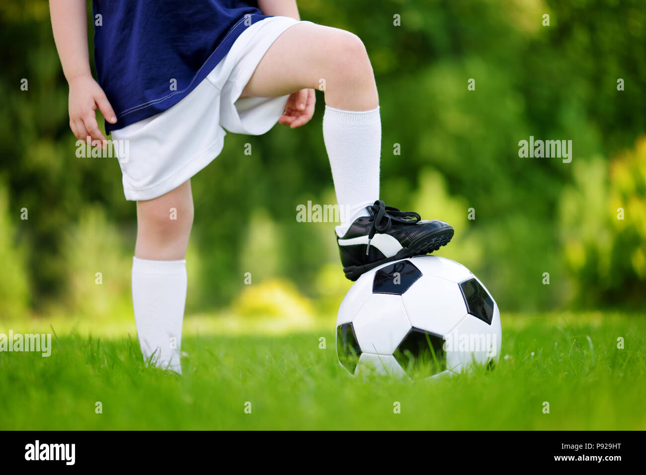 Close-up of a child having fun playing a soccer game on sunny summer ...
