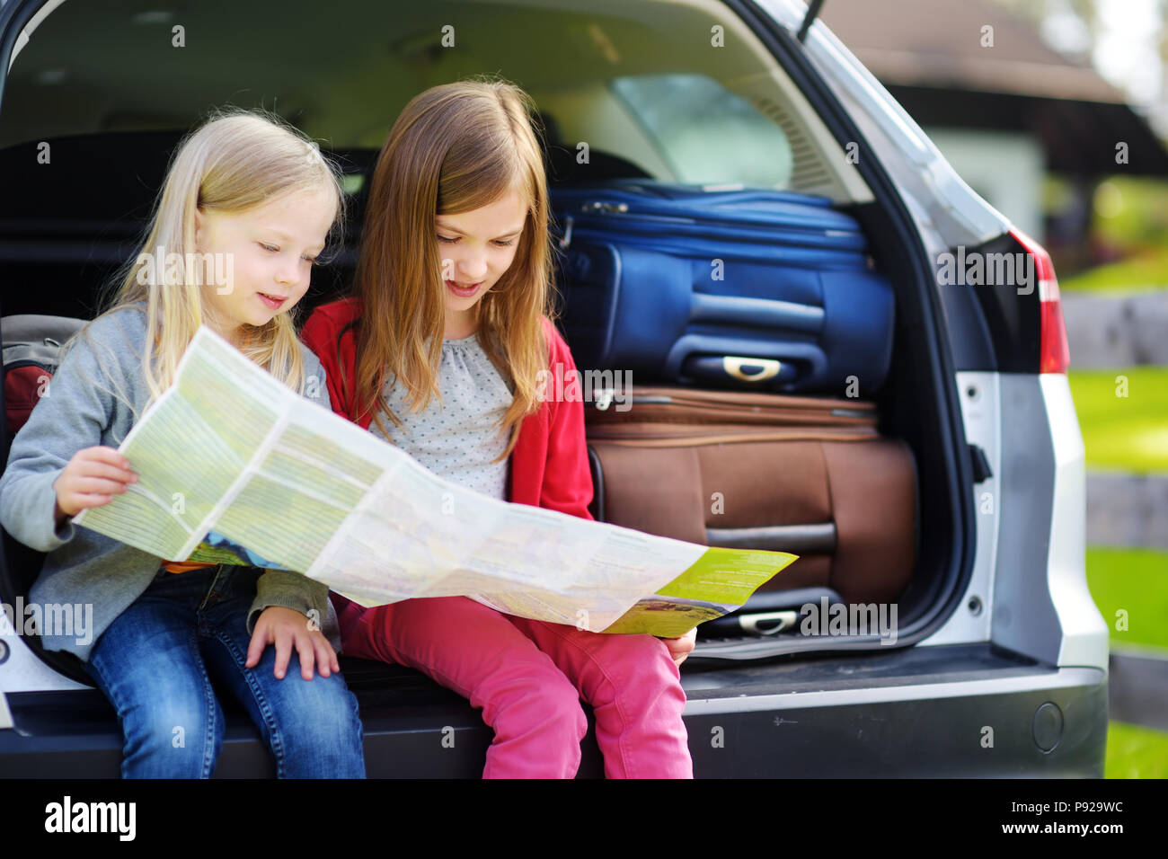 Two adorable little girls ready to go on vacations with their parents ...