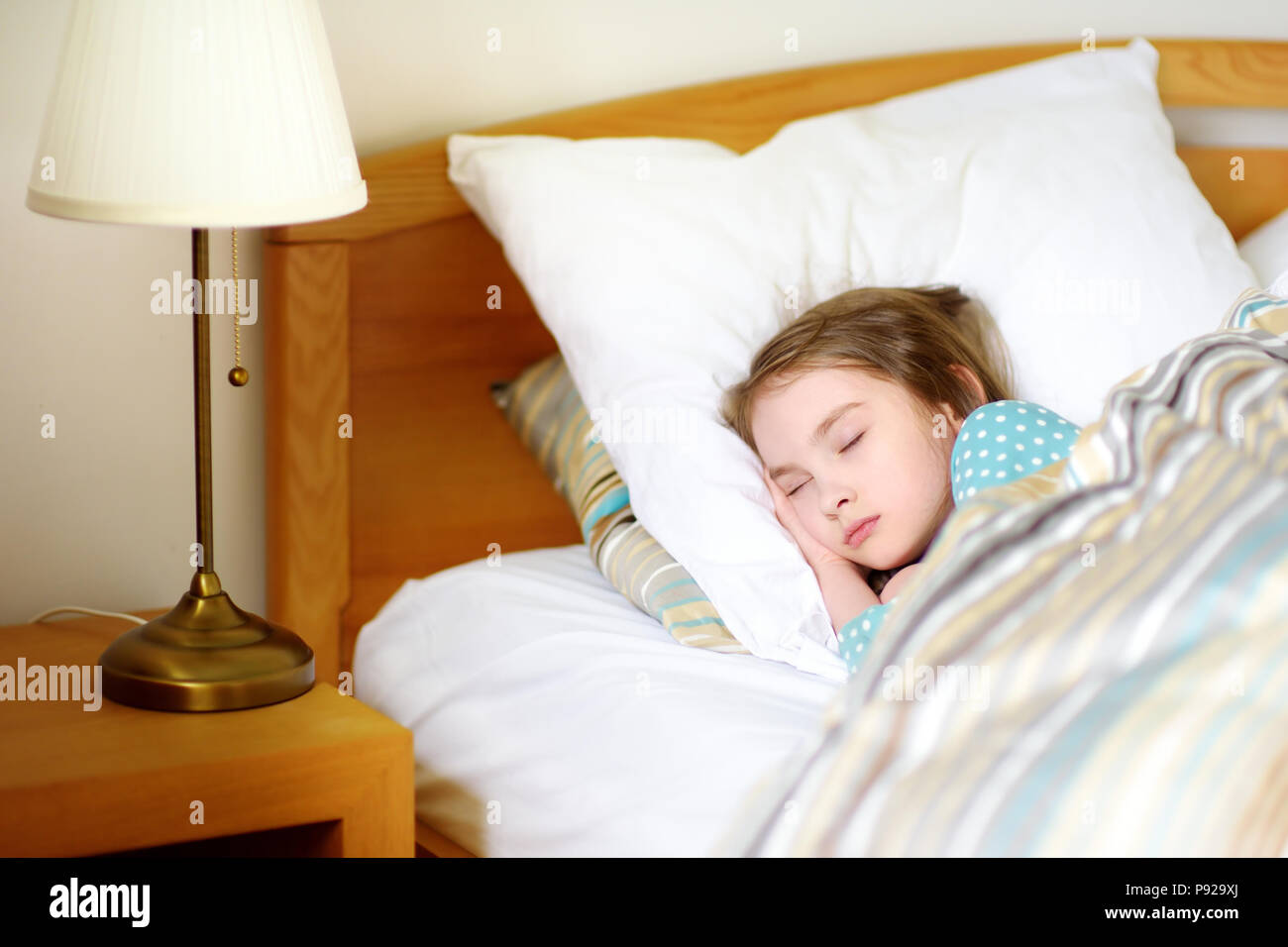 Adorable little girl sleeping in the bed. Tired child taking a nap ...