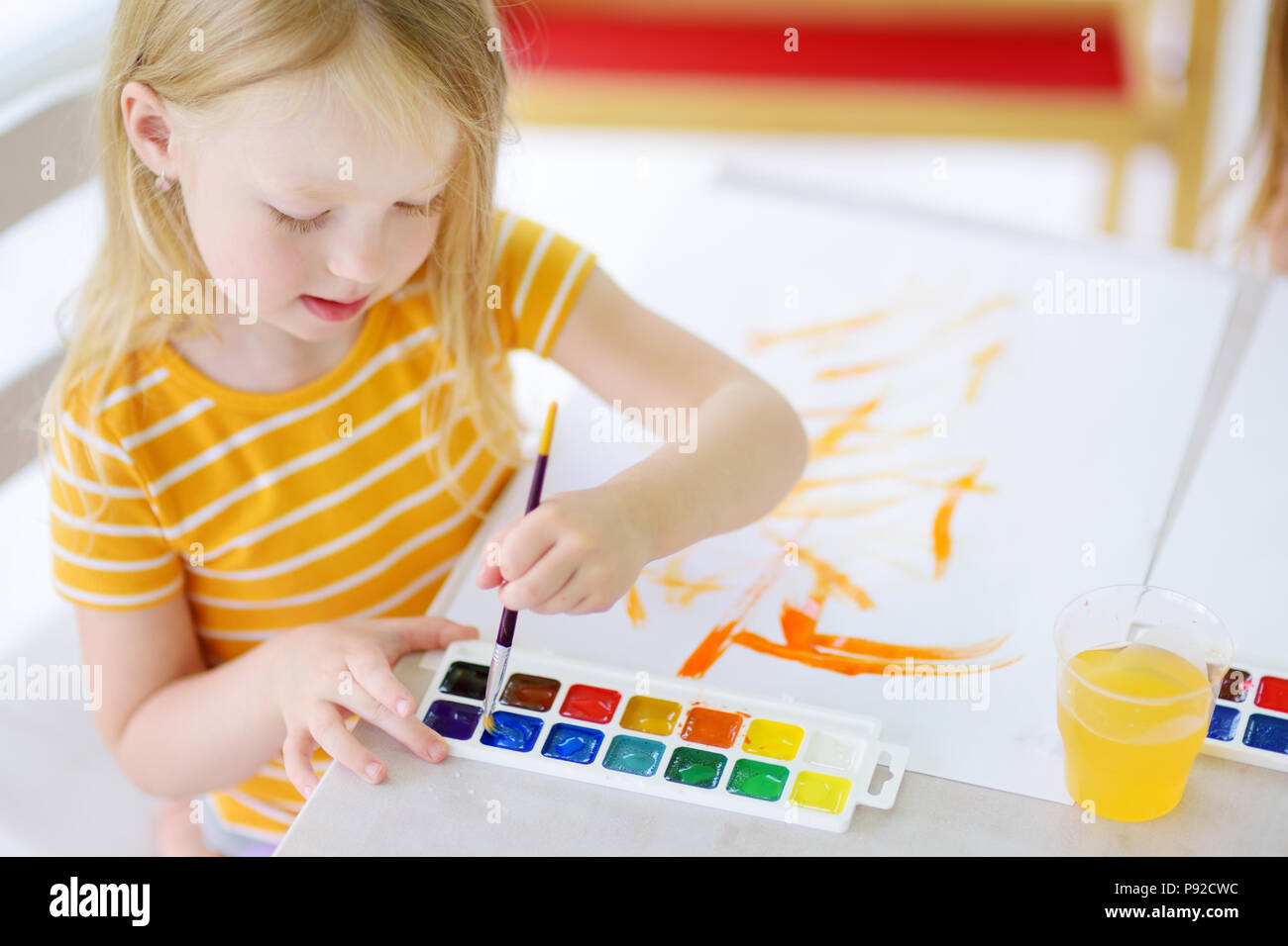 Cute little girl drawing with colorful paints at a daycare. Creative ...