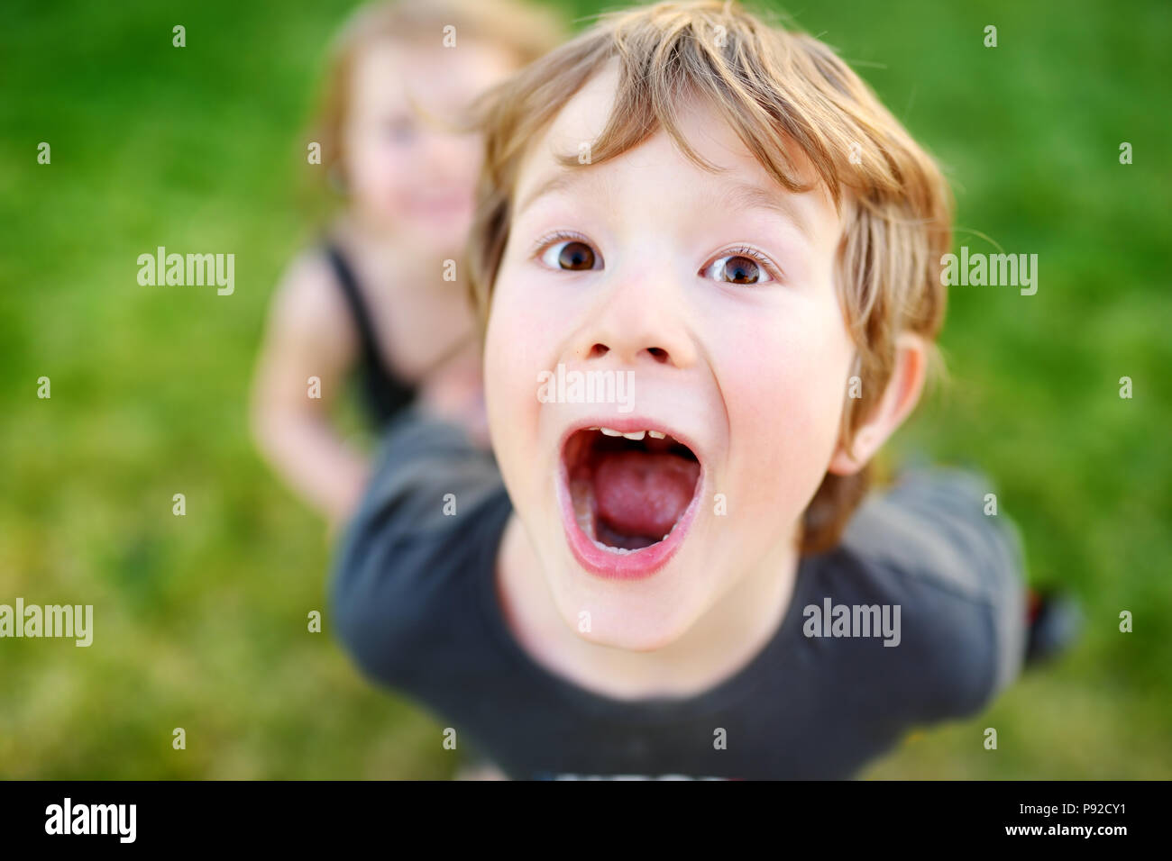Funny little boy shouting and making funny faces outdoors Stock Photo ...