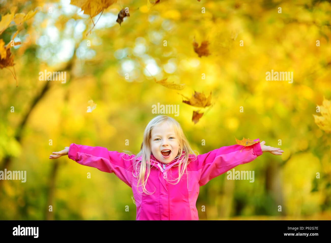 Cute little girl having fun on beautiful autumn day. Happy child ...
