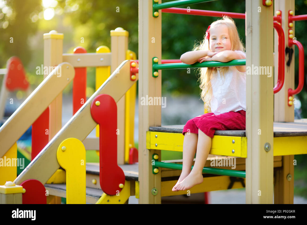 Cute little girl having fun on a playground outdoors in summer. Sport ...