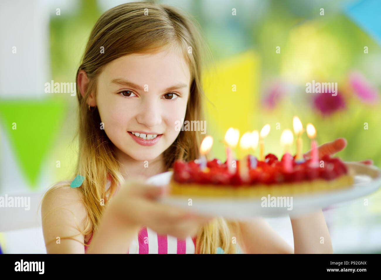 Adorable preteen girl having birthday party at home, blowing candles on ...