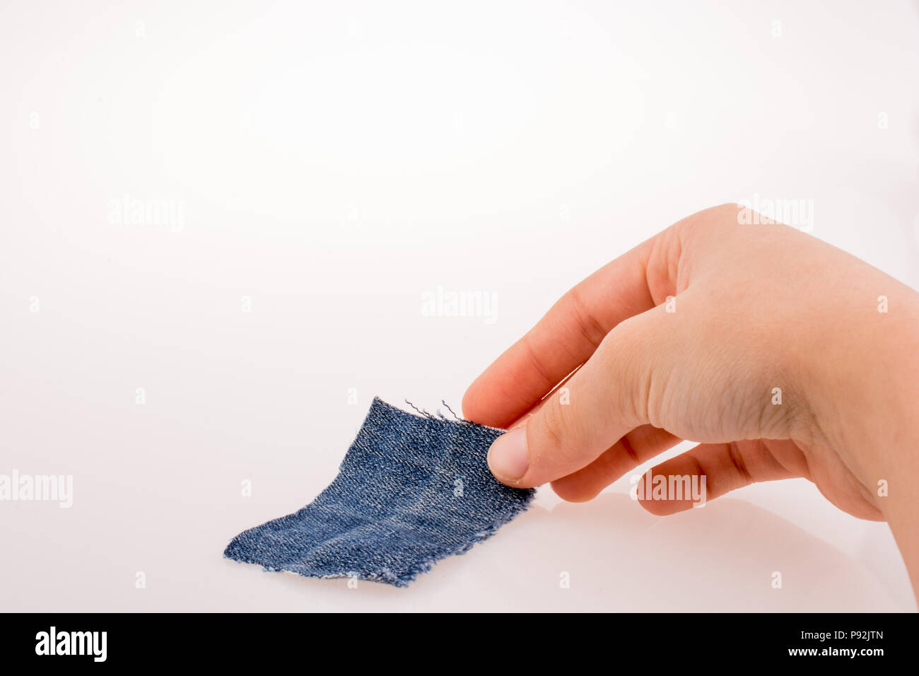 Hand in touch with a piece of denim fabric on white background Stock ...