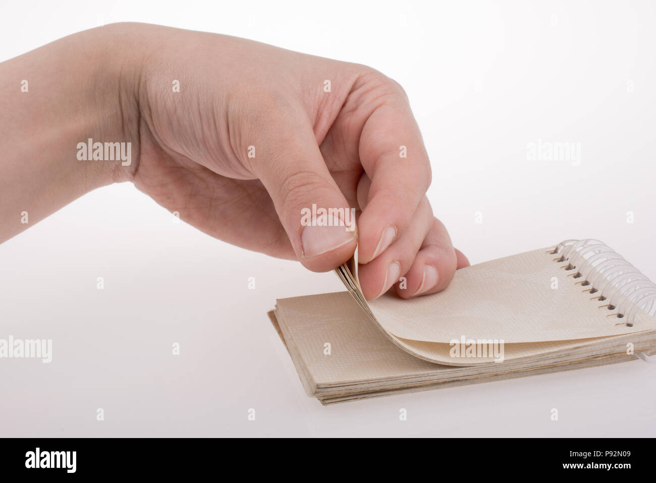 Hand holding a spiral notebook on a white background Stock Photo - Alamy