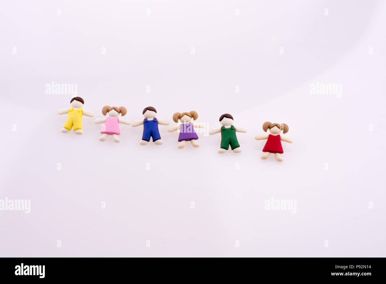 Colorful dressed children figures on a white background Stock Photo - Alamy