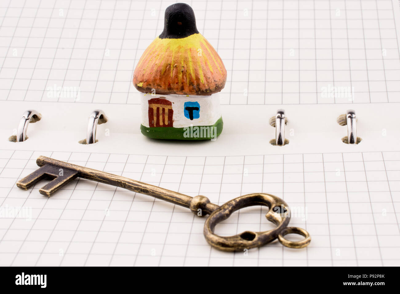 Hut model besides a key on a spiral notebook Stock Photo - Alamy