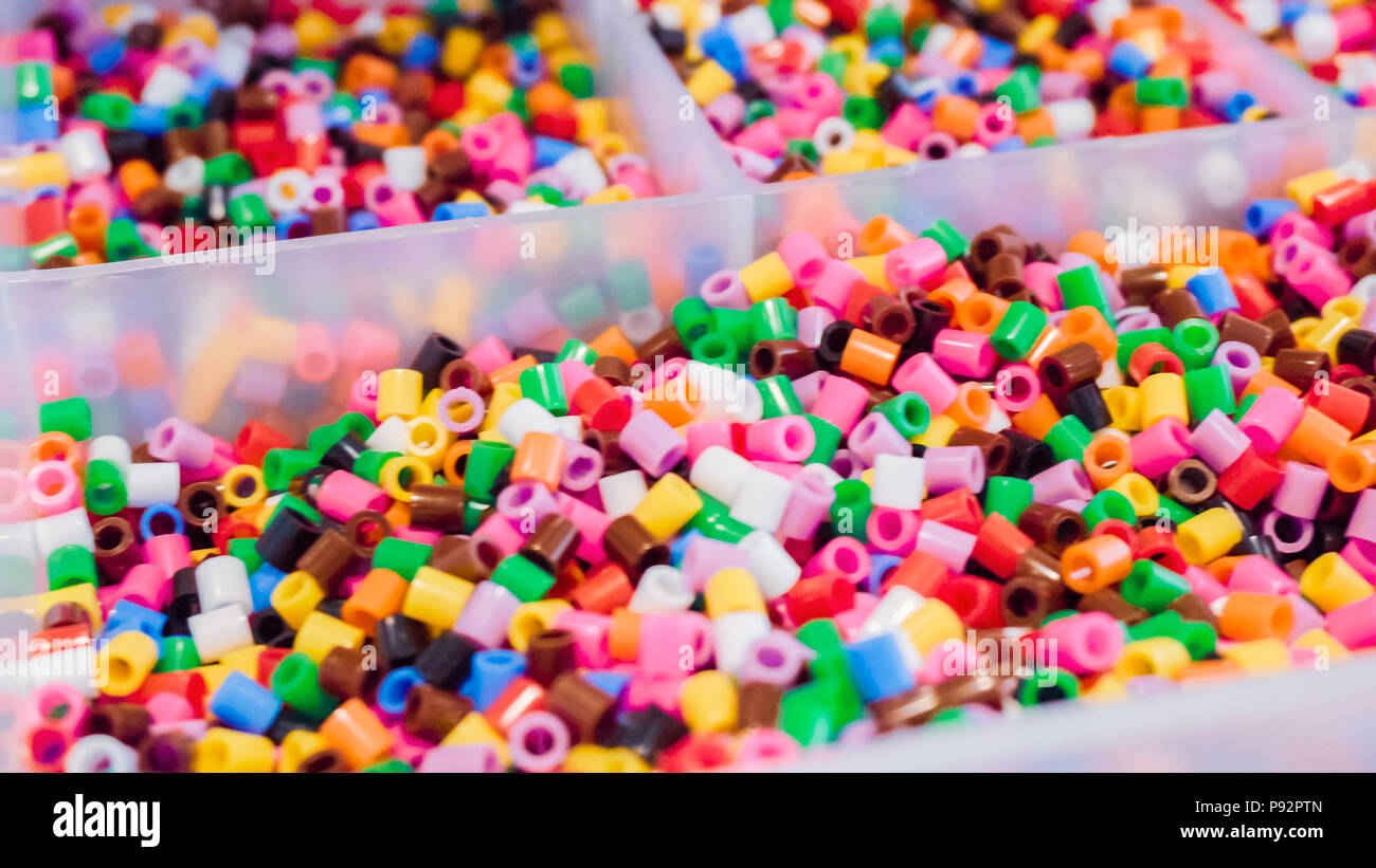 Plastic container with colorful kids beads Stock Photo - Alamy