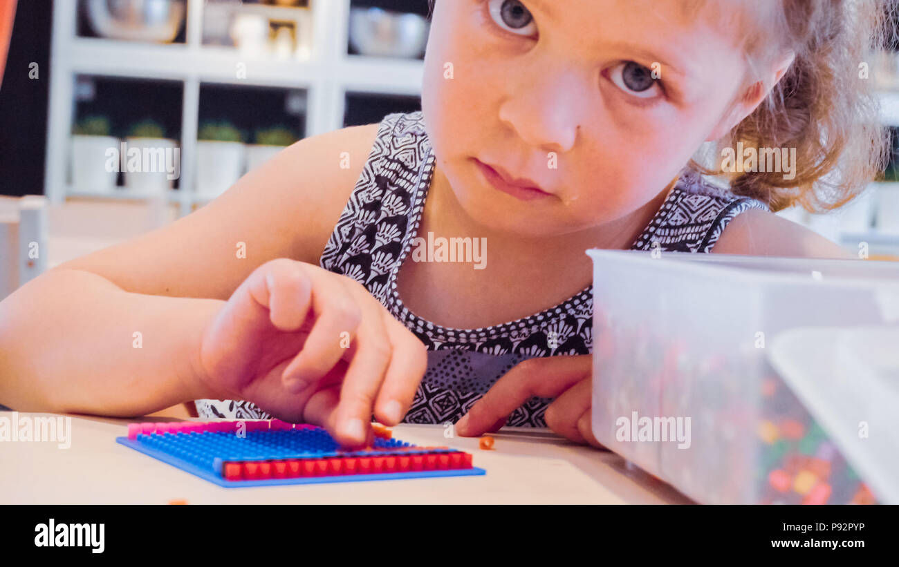 Little girl making bracelet from colorful kids beads Stock Photo - Alamy