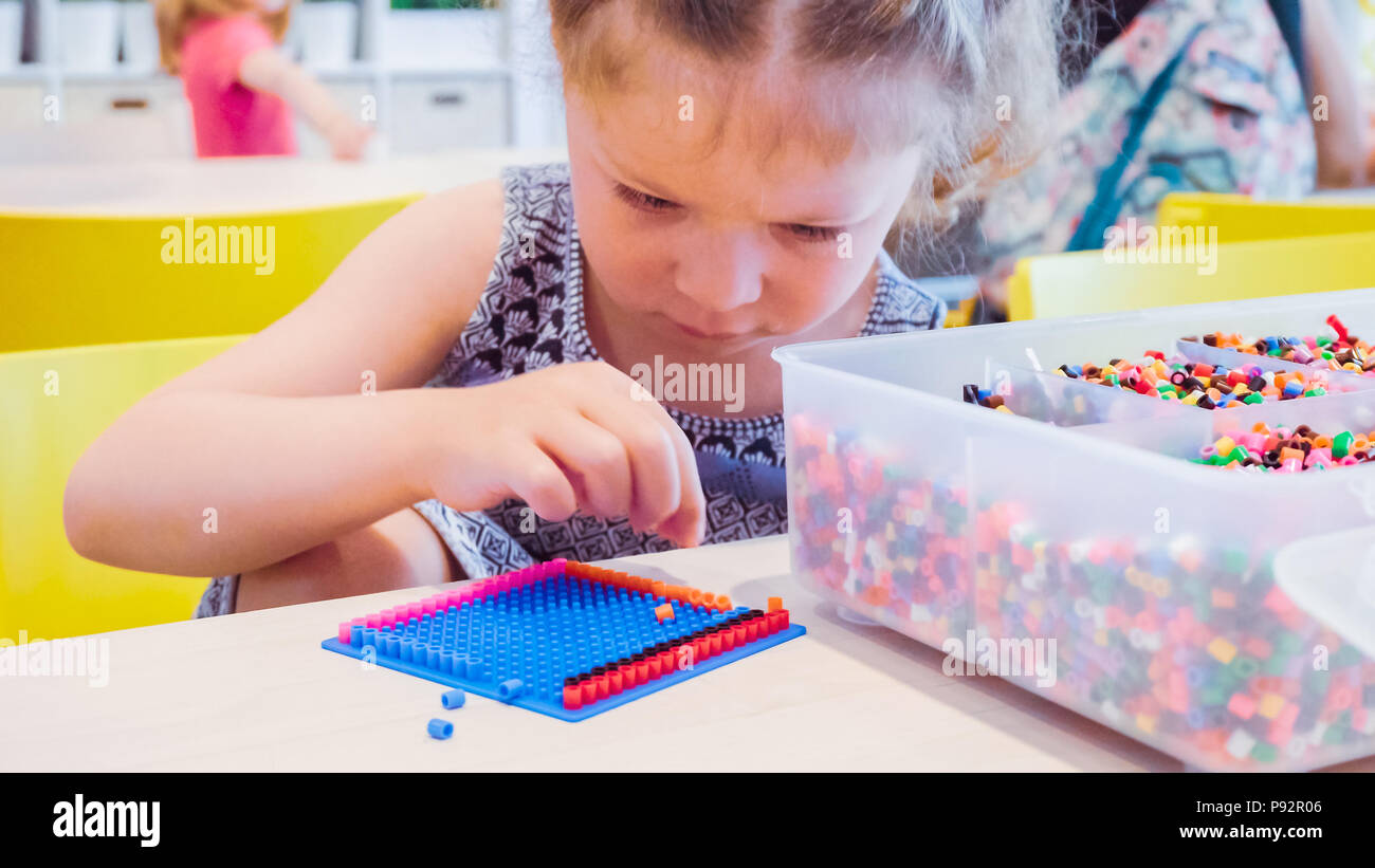 Little girl making bracelet from colorful kids beads Stock Photo - Alamy