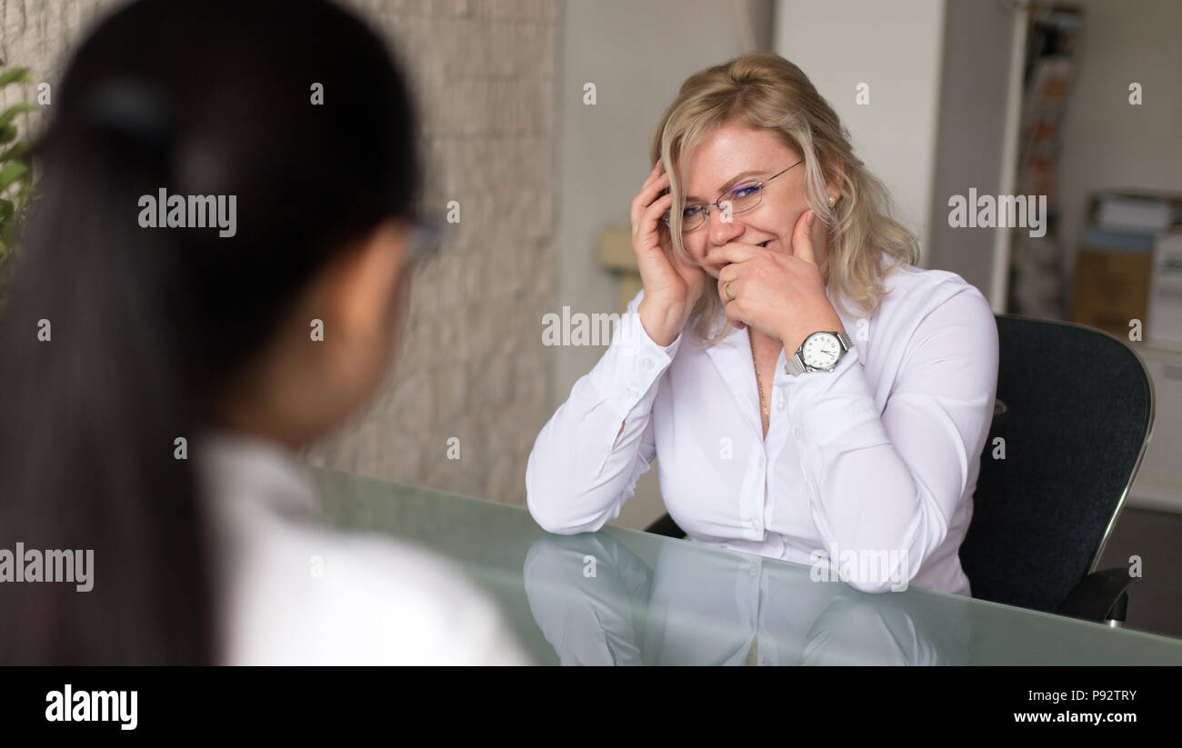 Candidate woman laughing during job interview in office Stock Photo - Alamy