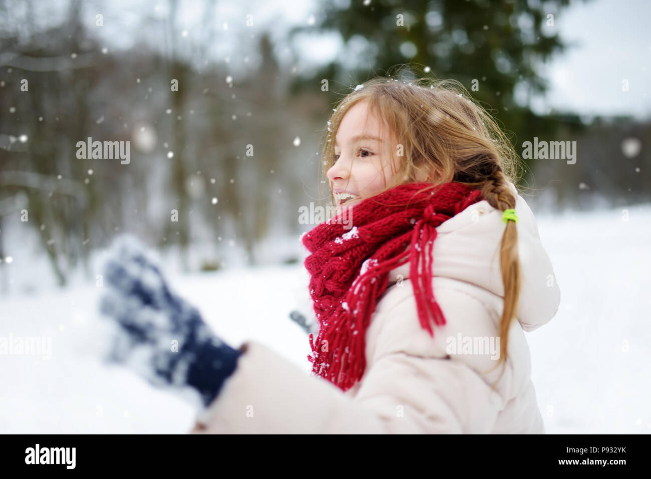 Adorable little girl having fun in beautiful winter park. Cute child ...
