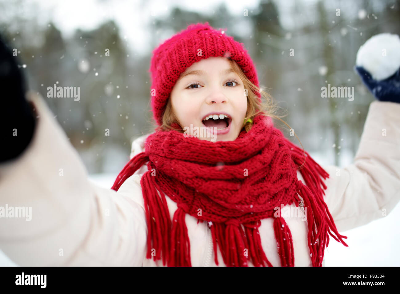 Adorable little girl having fun in beautiful winter park. Cute child ...