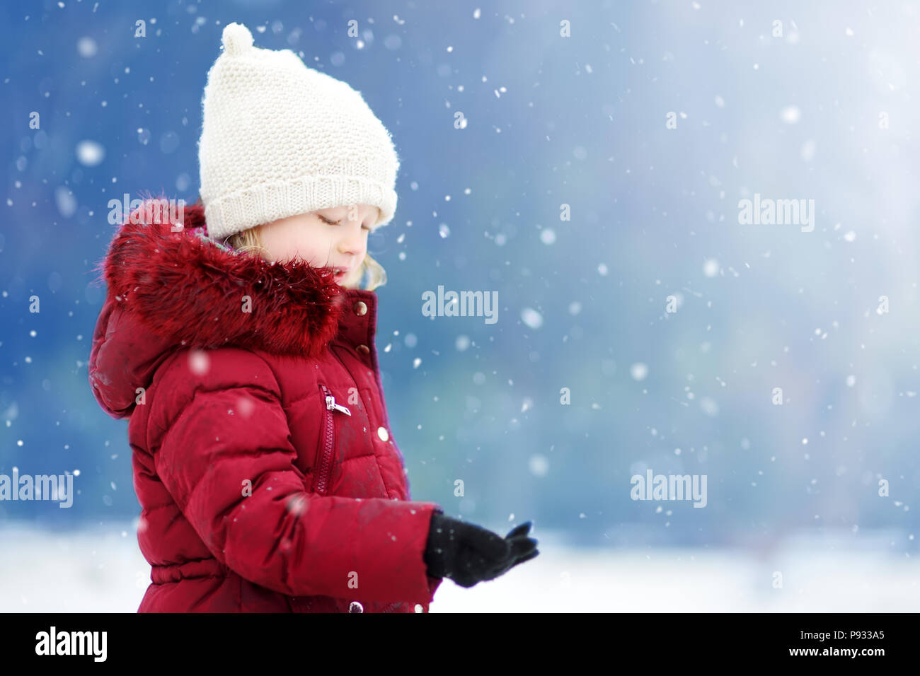 Adorable little girl having fun in beautiful winter park. Cute child ...