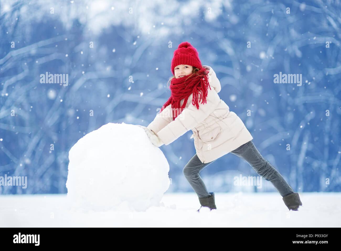 Adorable little girl building a snowman in beautiful winter park. Cute ...