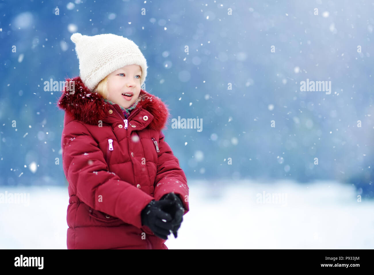 Adorable little girl having fun in beautiful winter park. Cute child ...
