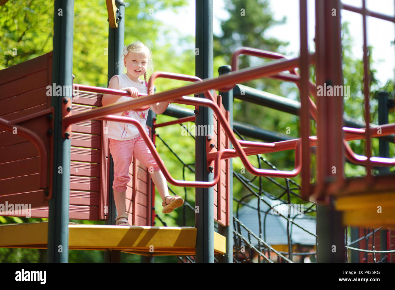 Cute little girl having fun on a playground outdoors in summer. Sport ...