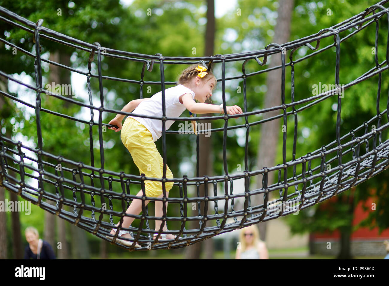 Cute little girl having fun on a playground outdoors in summer. Sport ...