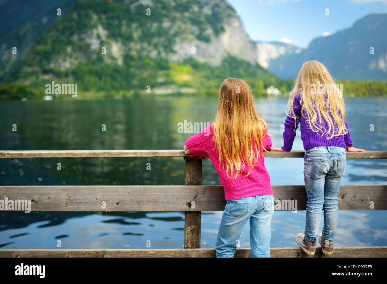 Two little girls enjoying the scenic view of Hallstatt lakeside town in ...