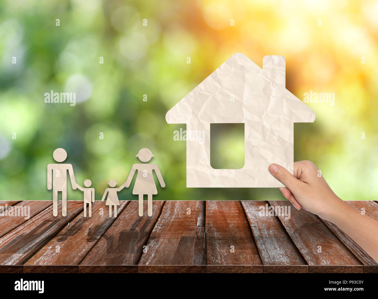 Concepts of Hand put House and family on Wood table top Stock Photo - Alamy