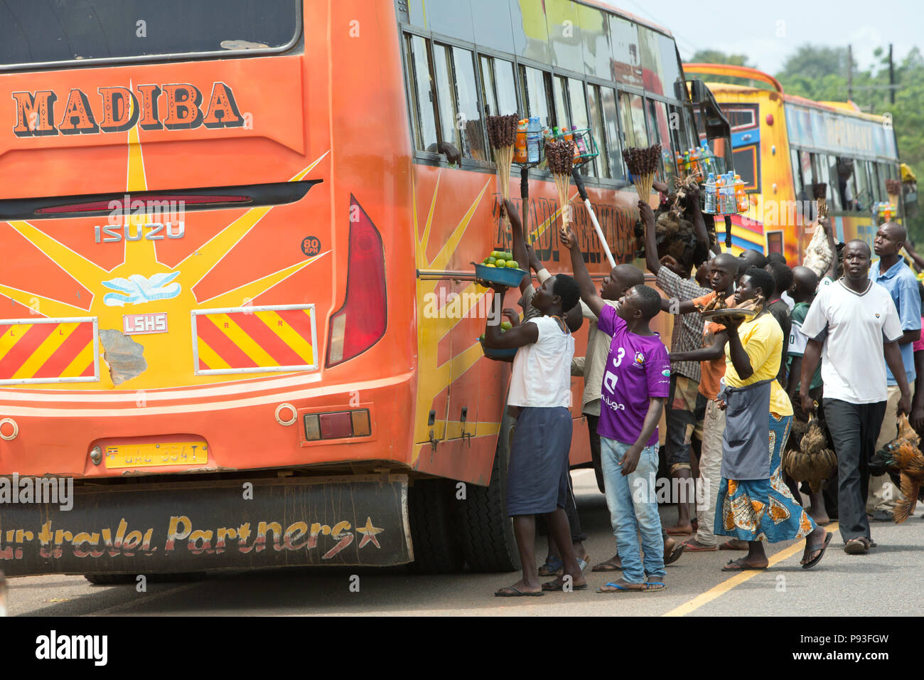 Kamdini, Uganda - At a bus stop, flying merchants offer travelers a ...